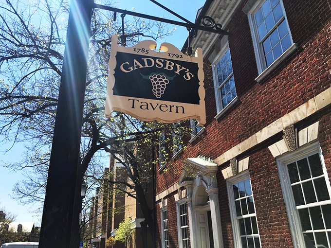 The historic fa&ccedil;ade of Gadsby's Tavern beckons with its colonial charm. That hanging wooden sign has been welcoming hungry patriots since 1785.