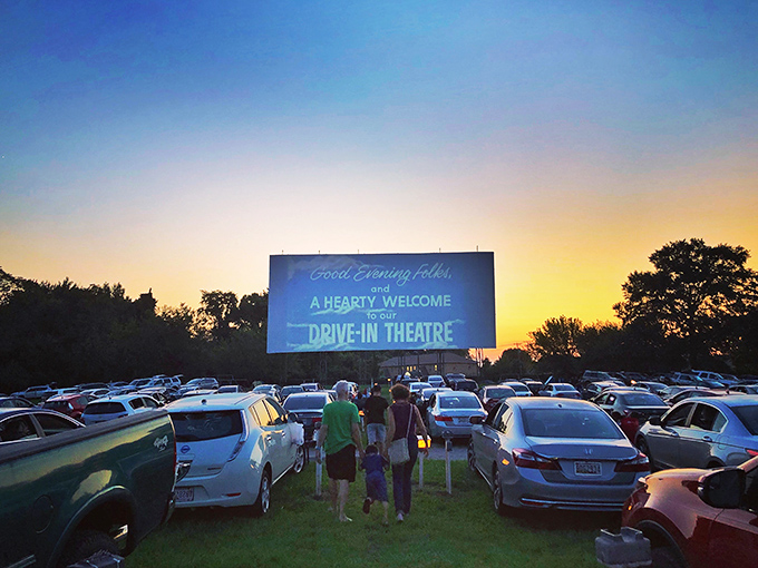 Twilight magic unfolds as families gather beneath Bengies' massive screen, where the "Good Evening Folks" welcome glows against a Maryland sunset.