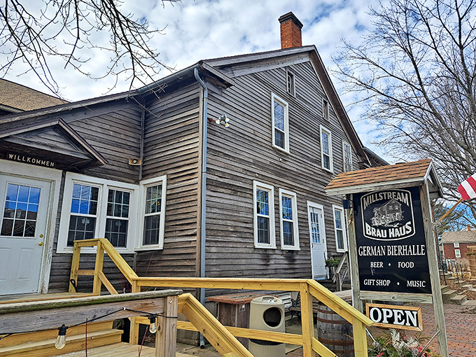 The weathered wooden exterior of Millstream Brau Haus stands like a time capsule from old-world Germany, miraculously transported to the Iowa countryside.