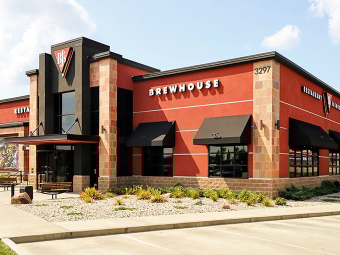 The bold red exterior of BJ's stands like a beacon for hungry travelers, promising craft brews and comfort food within those stone-accented walls.