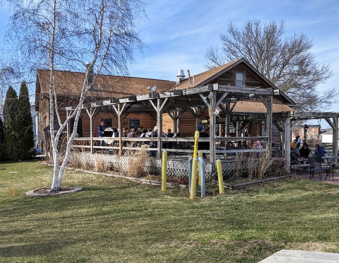 The weathered wooden exterior of Millstream Brau Haus stands like a time capsule from old-world Germany, miraculously transported to the Iowa countryside.