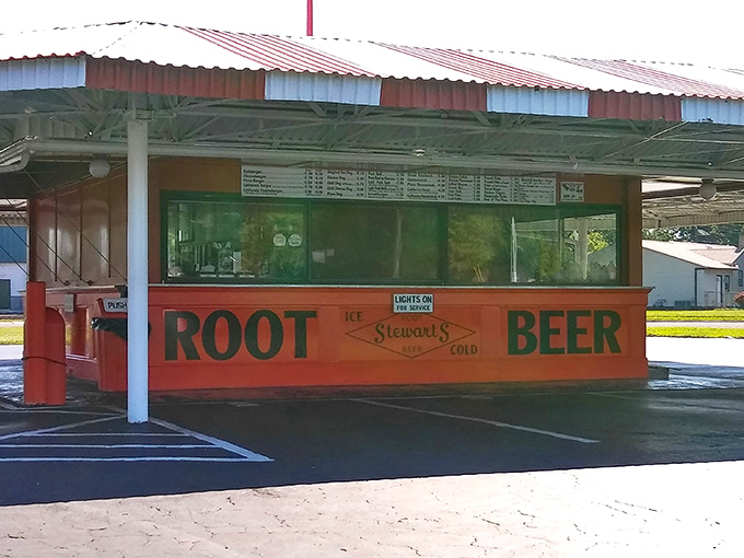 The iconic red and white striped canopy of Stewart's Drive-In stands like a time capsule on wheels, beckoning hungry travelers with promises of nostalgia and root beer.