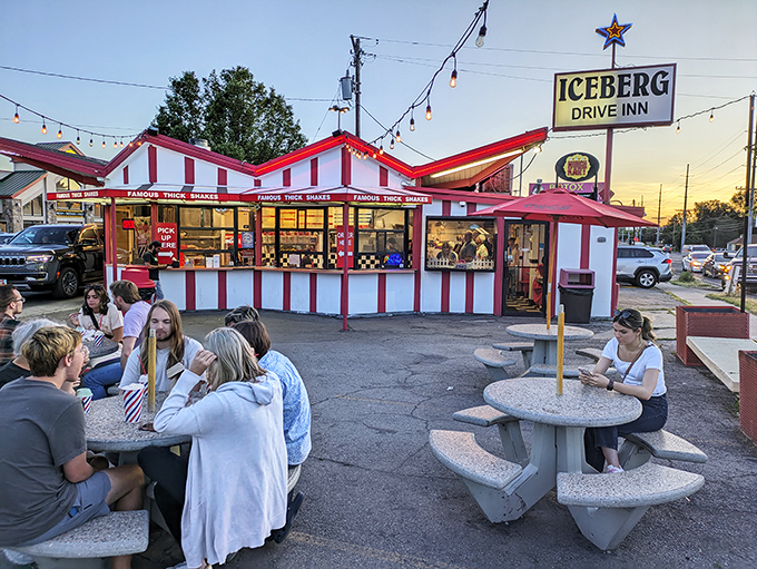 The iconic red and white striped exterior of Iceberg Drive Inn stands like a time capsule on 3900 South, promising nostalgic delights within.