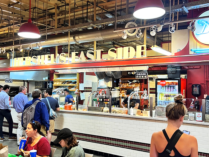 The neon "Deli" sign glows like a beacon of hope for the hungry. At Hershel's counter, sandwich artisans transform simple ingredients into edible masterpieces.