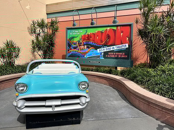The entrance sets the stage perfectly&mdash;a vintage convertible parked beneath a retro marquee that promises cinematic dining adventures ahead.