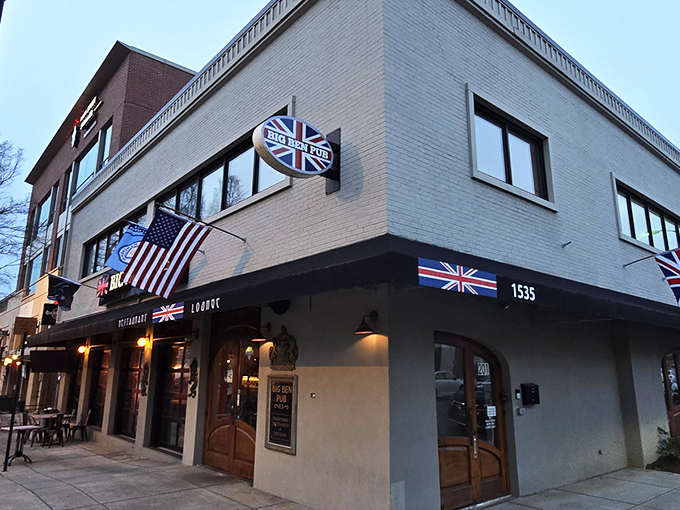 The Union Jack proudly announces your arrival at Big Ben Pub, where those magnificent wooden doors might as well be a portal straight to London.