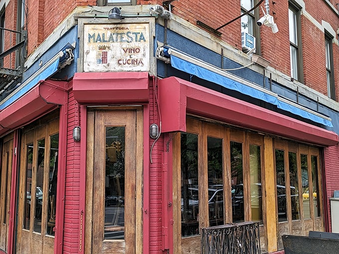 The corner where pasta dreams come true. Malatesta's weathered sign and rustic wooden windows promise authentic Italian comfort without pretension.