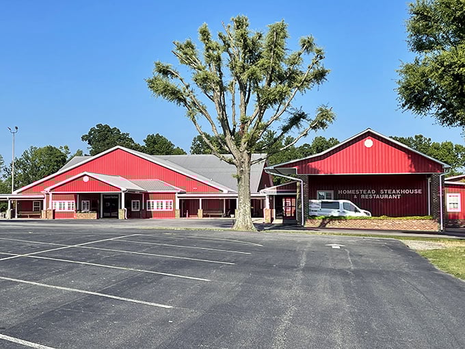 The barn-red exterior of Homestead Steakhouse stands proud against Carolina blue skies, like a beacon calling hungry travelers home.