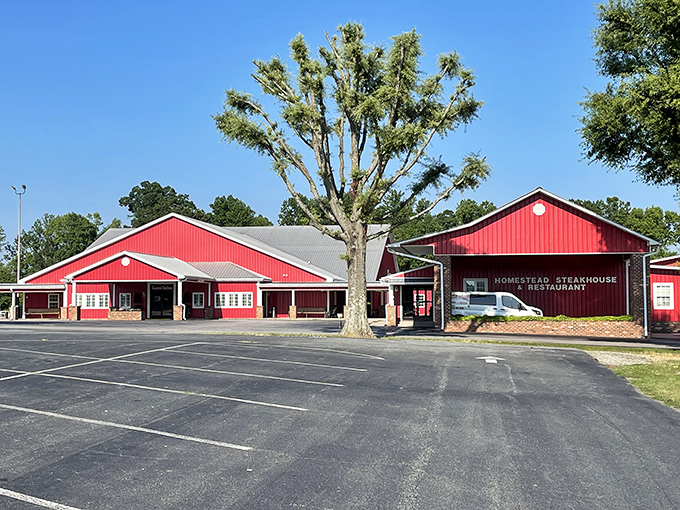 The barn-red exterior of Homestead Steakhouse stands proud against Carolina blue skies, like a beacon calling hungry travelers home.