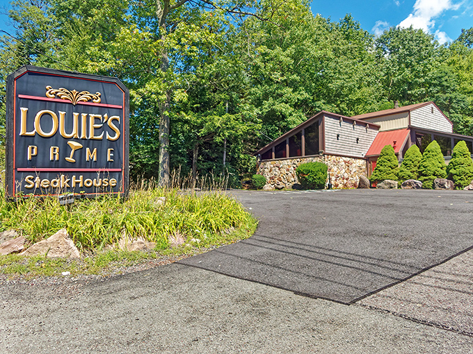 The forest parts to reveal culinary treasure – Louie's Prime Steak House stands proudly among the trees, its stone foundation and wooden charm beckoning hungry travelers.