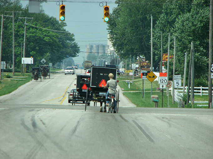 Where time travels at eight miles per hour. Amish buggies with their iconic orange safety triangles share the road with modern vehicles in Shipshewana.