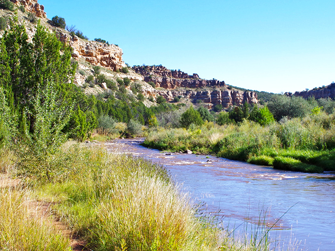Nature's grand theater unfolds at Villanueva, where sandstone cliffs stand like ancient sentinels guarding the verdant valley below. 