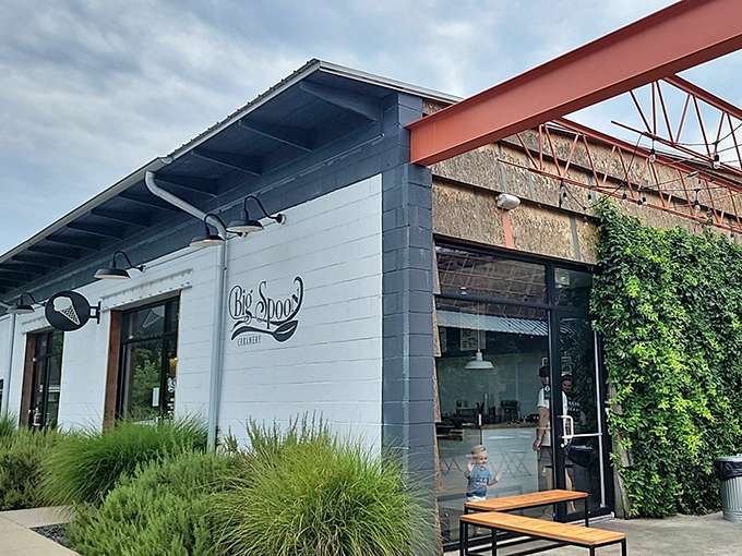 Big Spoon Creamery's white-brick exterior glows like a beacon of dairy-based hope after dark, promising sweet relief from Alabama's summer heat.