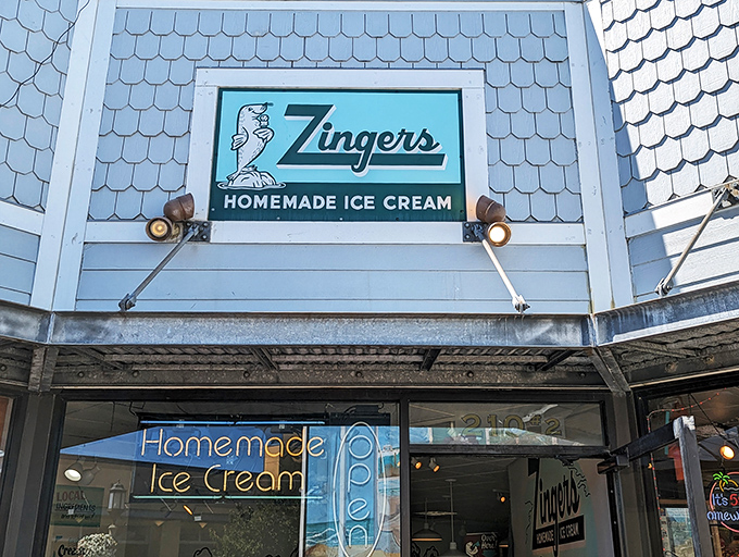 The iconic blue-shingled exterior of Zingers stands like a beacon of sweet promises on Seaside's Broadway Street, complete with their playful sea lion mascot. 