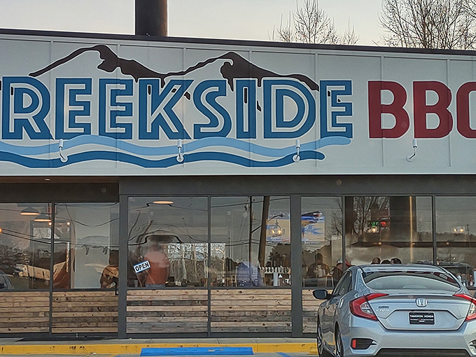 The blue and red Creekside BBQ sign beckons like a lighthouse for the hungry, promising smoky treasures inside this Pelham landmark.