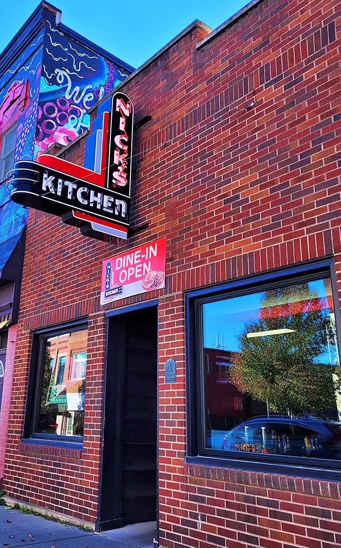The iconic neon sign of Nick's Kitchen stands as a beacon of culinary history on Huntington's Jefferson Street. A century of tenderloin tradition lives behind this brick fa&ccedil;ade.