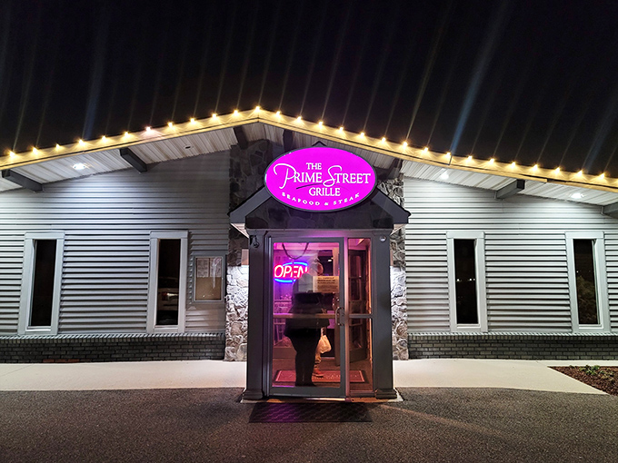 The neon pink sign glows like a beacon in the night, promising culinary treasures inside this unassuming roadside building.