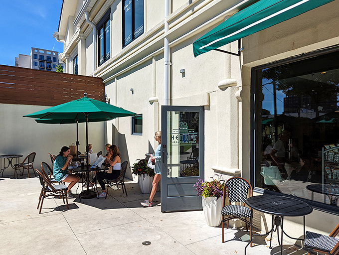 A little slice of heaven with green umbrellas providing shade as diners enjoy their meal on Henri's inviting outdoor patio. The perfect urban oasis.