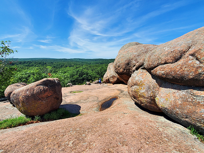 Nature's sculpture garden spans the horizon, where billion-year-old pink granite boulders rest like gentle giants against Missouri's emerald landscape.
