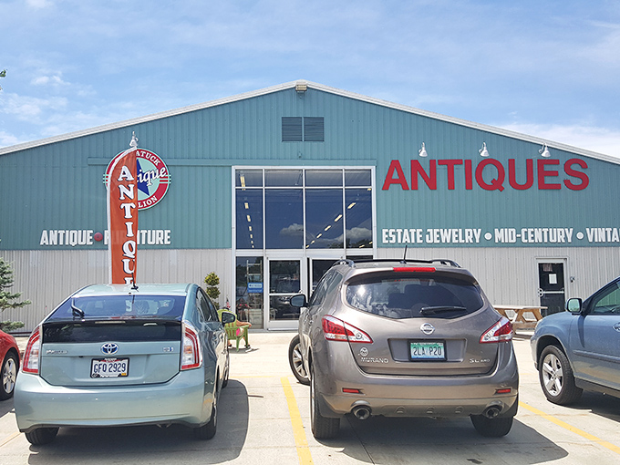 The mint-green exterior of Saugatuck Antique Pavilion stands proudly against a blue Michigan sky, with a classic convertible parked out front&mdash;nostalgia in architectural and automotive form. 