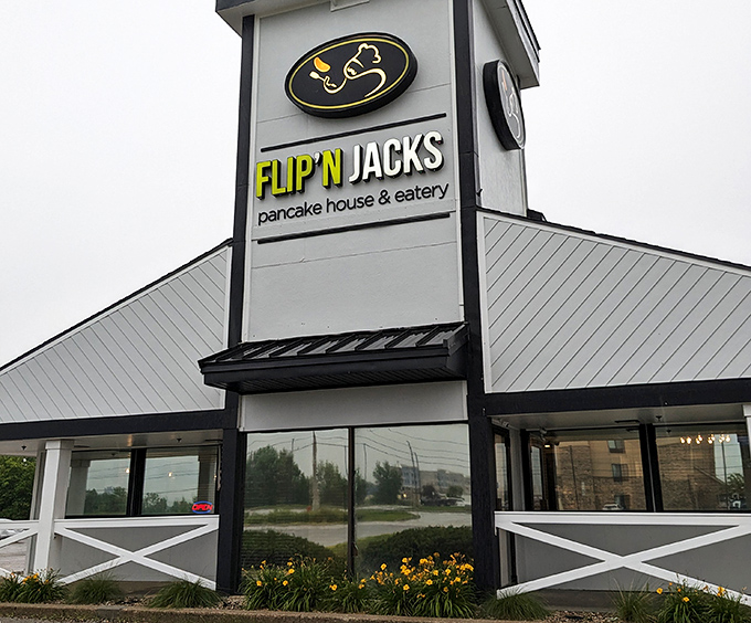 The distinctive peaked roof and farmhouse-style railing of Flip'N Jacks stands like a breakfast beacon in Ames, promising pancake paradise within.