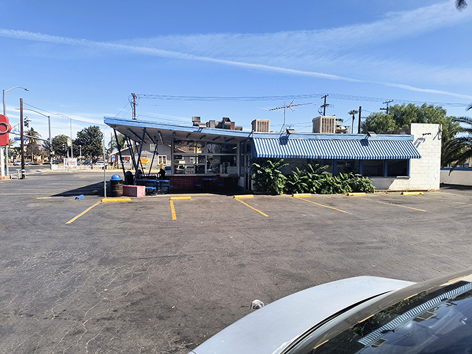 The blue-striped awning of George's Drive-In stands like a beacon of burger paradise against the California sky, promising delicious nostalgia with every order. Photo credit: D OhOh
