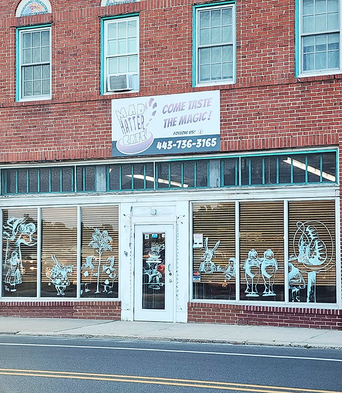 The brick facade of Mad Hatter Cafe beckons with whimsical window art&mdash;Lewis Carroll's fantasy brought to life on Salisbury's Main Street.
