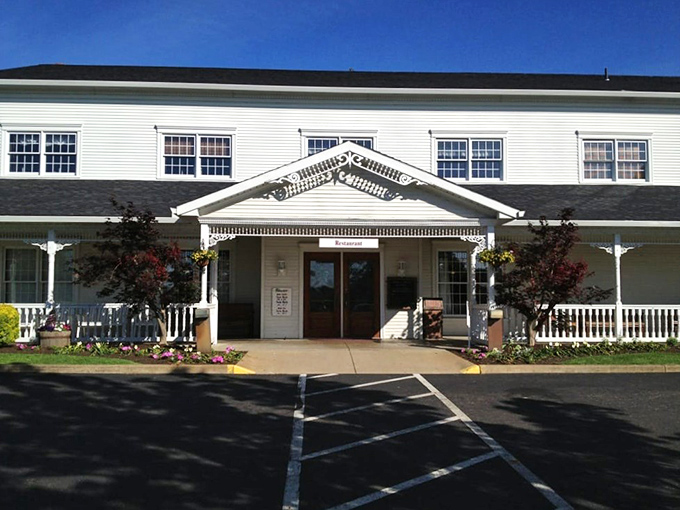 The classic white clapboard exterior of Amish Door Restaurant stands like a welcoming beacon, complete with wraparound porch and vibrant flower beds that change with Ohio's seasons.