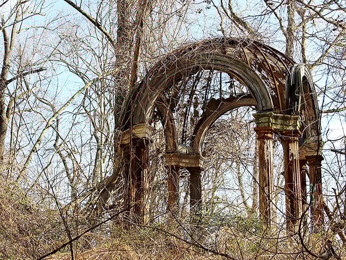 The haunting centerpiece of Hell House: a metal cross stands sentinel within weathered columns, like a scene from a gothic novel come to life.