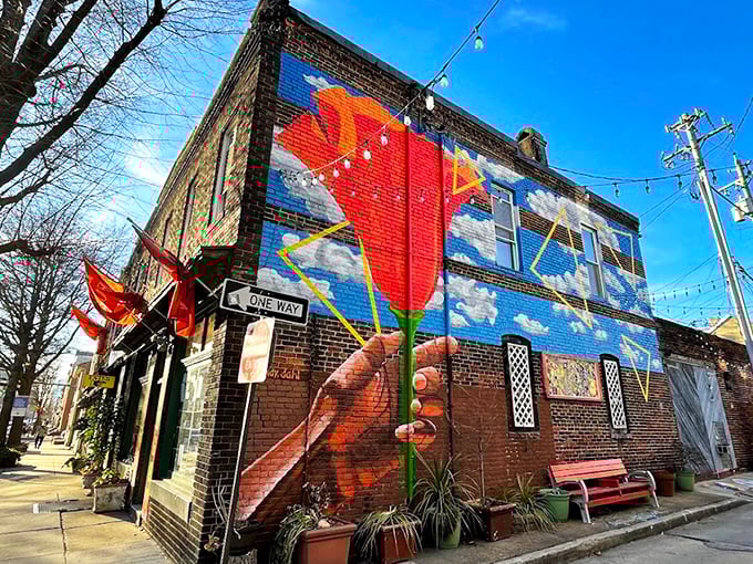 The exterior mural transforms this brick building into a vibrant landmark. Who needs subtle signage when you can have a giant hand holding a flower against the sky?