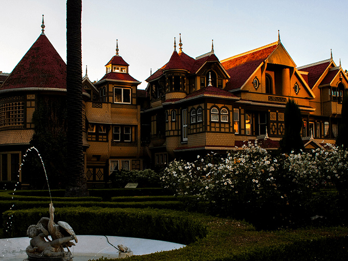 The Winchester Mystery House looms against the sky, its Victorian fa&ccedil;ade hiding countless architectural oddities that would make Escher scratch his head in confusion.