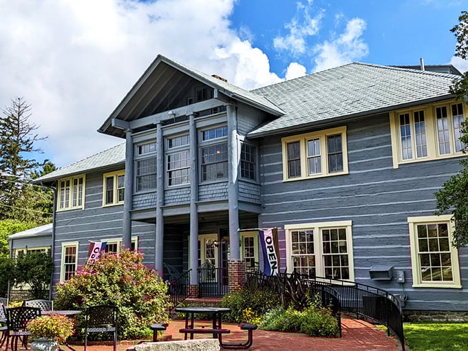 The stately blue Log House Craft Gallery stands like a guardian of Appalachian tradition, proudly displaying its Berea College heritage beneath Kentucky's endless sky.