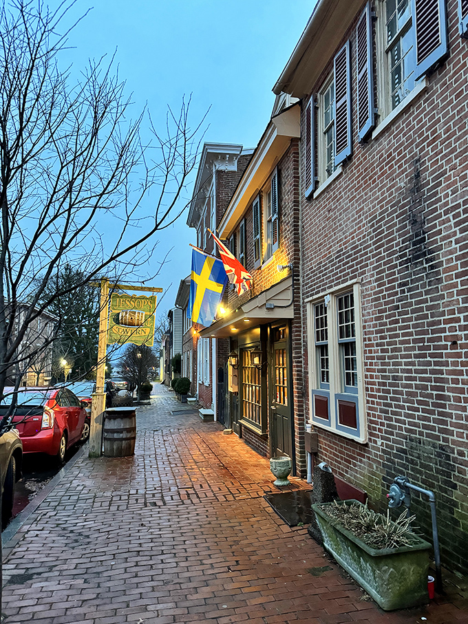 History flies proudly outside Jessop's Tavern, where international flags flutter above brick-lined streets that have witnessed centuries of American stories.