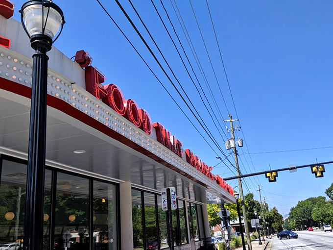 The iconic neon sign beckons like a lighthouse for hungry souls. Art Deco curves and that glorious "FOOD" proclamation—sometimes the simplest promises are the best ones.