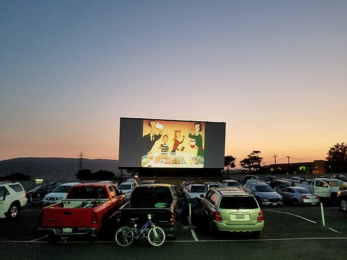 The magic hour at Sunset Drive-In, where cars gather like faithful pilgrims to worship at the altar of cinema under the twilight sky.