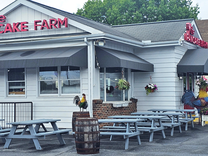 The iconic red Pancake Farm sign beckons hungry travelers like a breakfast lighthouse. Those picnic tables aren't just seating&mdash;they're the waiting room for pancake paradise.