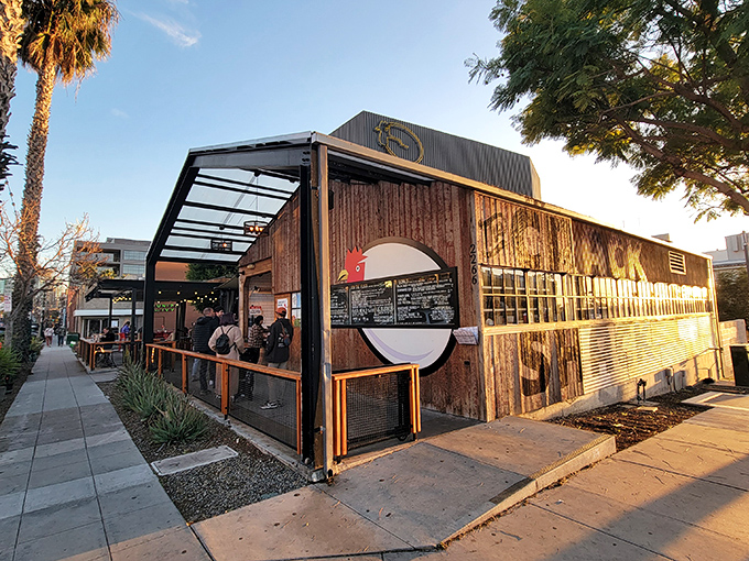 The rustic-industrial exterior of The Crack Shack beckons like a chicken-lover's mirage in Little Italy, where casual meets culinary genius under the San Diego sun.