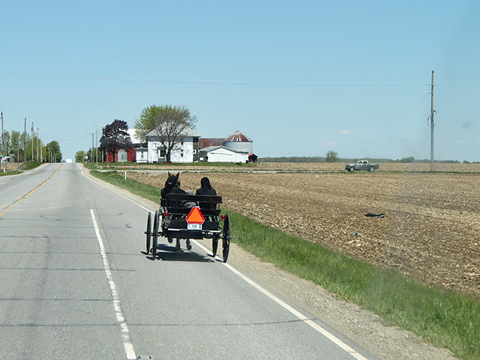 Where time travels at eight miles per hour. Amish buggies with their iconic orange safety triangles share the road with modern vehicles in Shipshewana. 