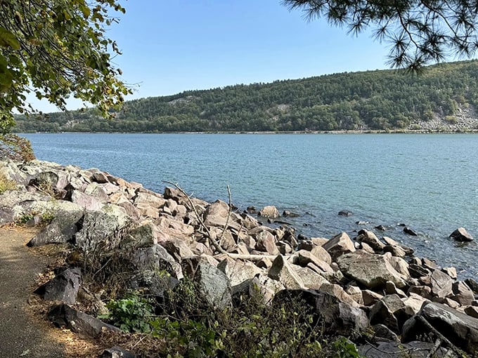 The shoreline tells ancient stories in stone. Devil's Lake's crystal waters meet million-year-old quartzite in nature's perfect handshake.