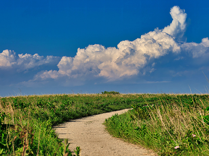 The path less traveled beckons with billowing clouds that look like nature's own cotton candy sculpture. Kansas skies have never been so dramatic.