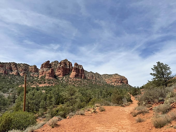 Nature's red carpet rolls out before you, leading to Bell Rock's majestic silhouette against that impossibly blue Arizona sky.
