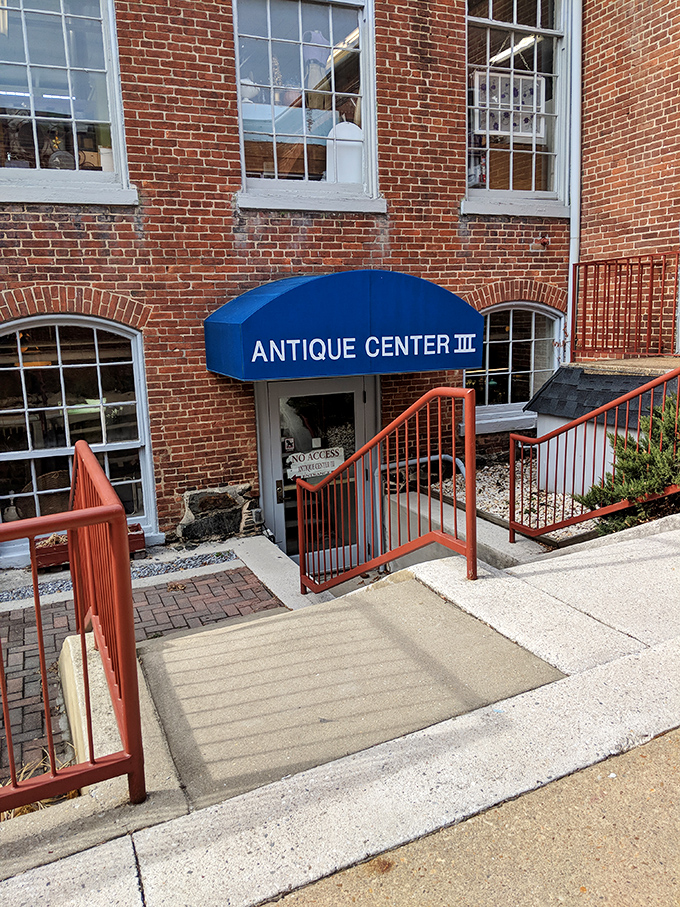 The historic brick exterior of Savage Mill welcomes treasure hunters with its distinctive blue awning&mdash;industrial architecture transformed into an antiquing paradise.
