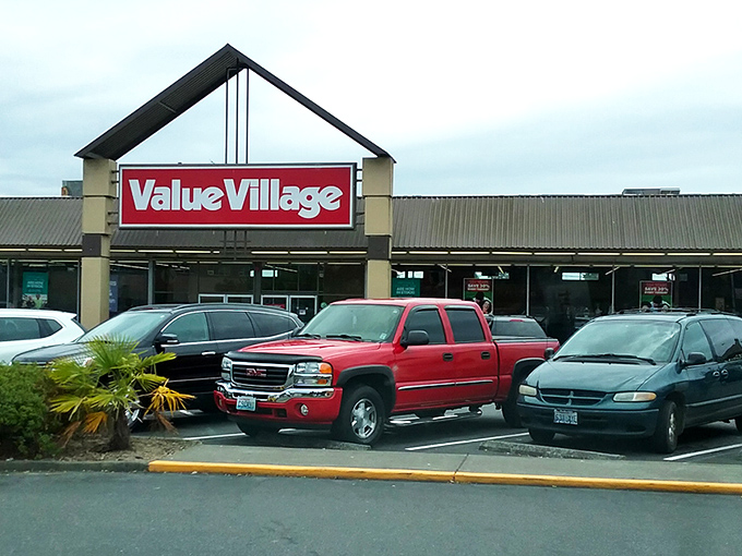 The iconic red Value Village sign beckons like a lighthouse for treasure hunters navigating the sea of suburban retail. Welcome to thrift paradise!