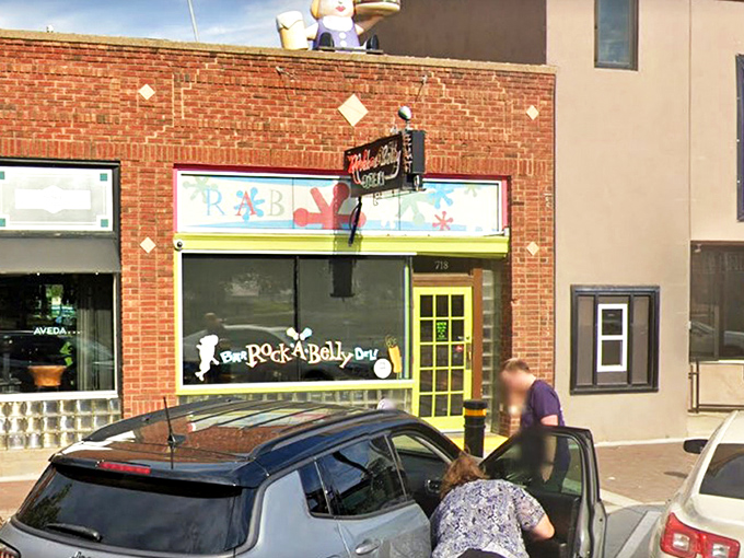The bright yellow door acts like a portal to flavor town, with that whimsical sandwich figure on the roof standing guard over culinary treasures below.