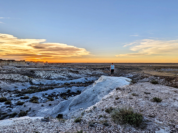 Sunset transforms Little Jerusalem into nature's greatest light show, painting the chalk formations in golden hues while a solitary explorer gains perspective on life's true scale.