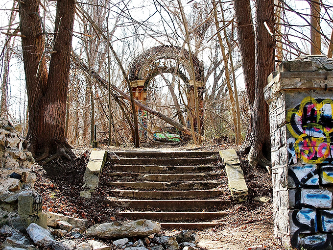 The haunting centerpiece of Hell House: a metal cross stands sentinel within weathered columns, like a scene from a gothic novel come to life.