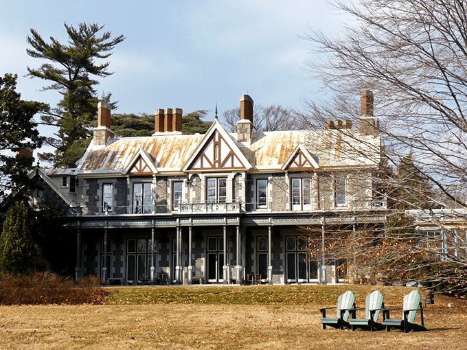 The mansion glows amber against the twilight sky, its stone façade and pointed gables silently whispering tales from another century. Like a Victorian ghost story come to life.