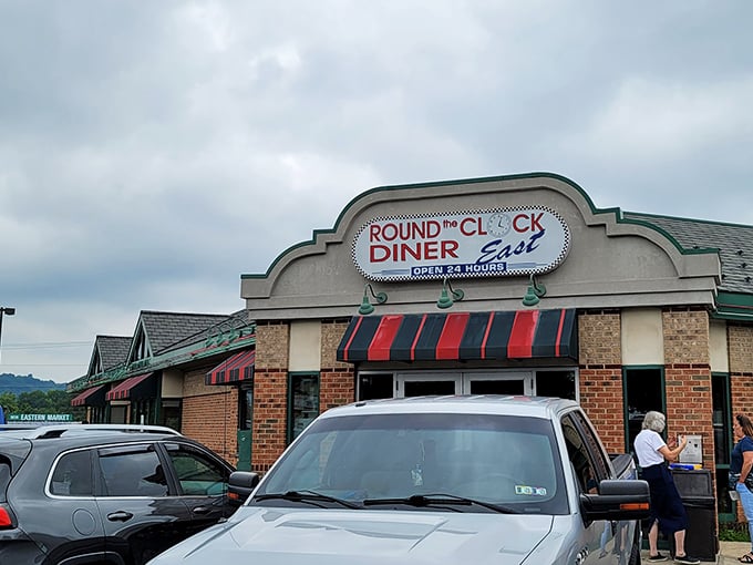 The classic brick exterior with its red and green awning stands like a beacon to hungry travelers. Diner paradise awaits 24/7!