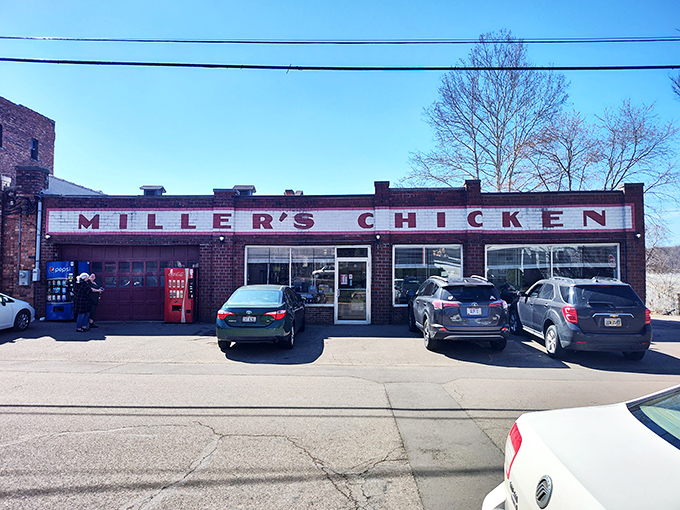 The unassuming exterior of Miller's Chicken stands as a time capsule of Americana, complete with vintage Coca-Cola machine standing guard like a red sentinel.