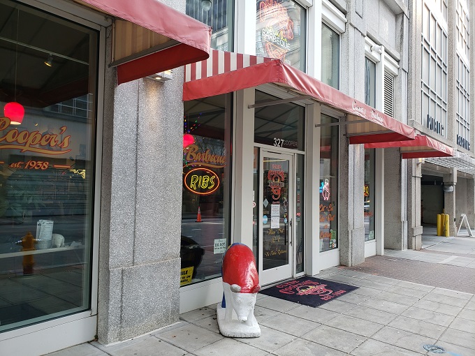 The neon glow of Clyde Cooper's storefront is like a lighthouse for hungry barbecue pilgrims, beckoning from downtown Raleigh since 1938. 
